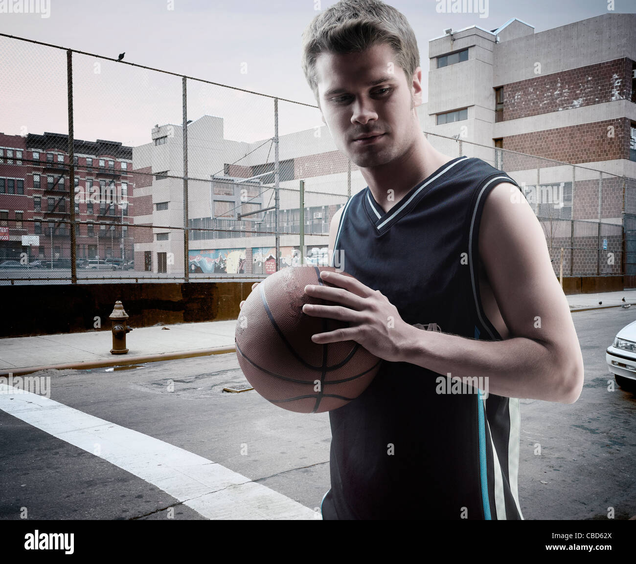 Man carrying basketball on city street Stock Photo - Alamy