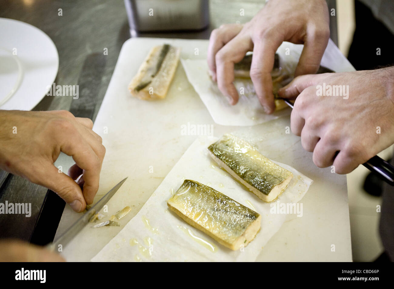 Chefs preparing fish, cropped Stock Photo - Alamy