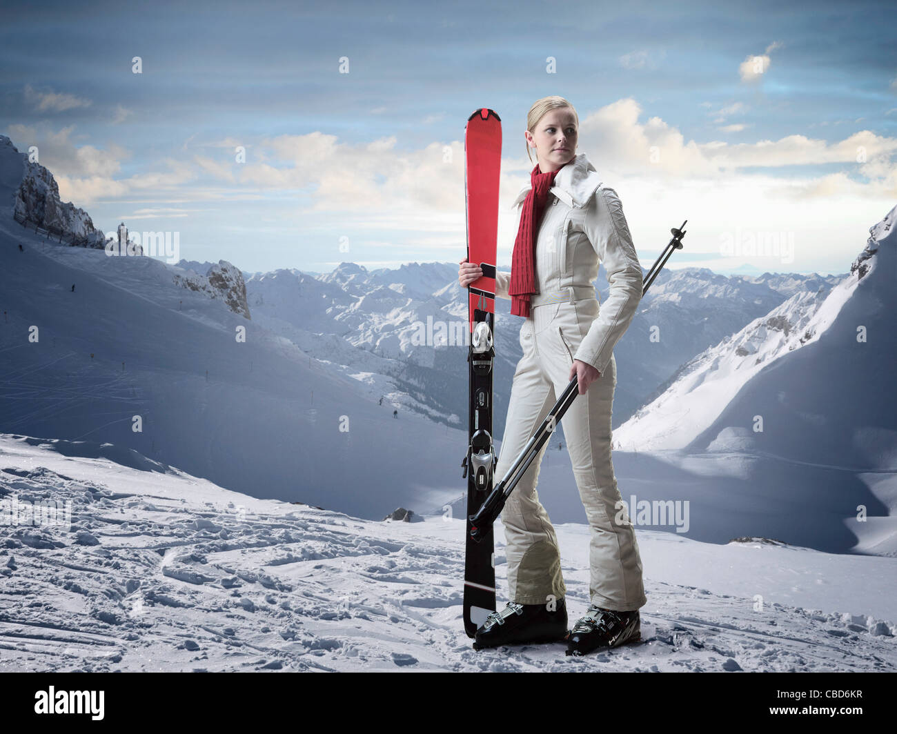 Woman carrying skis on snowy slope Stock Photo - Alamy