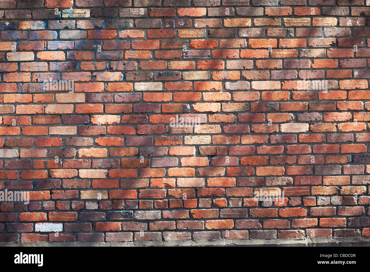 Red brick wall with mottled light Stock Photo - Alamy