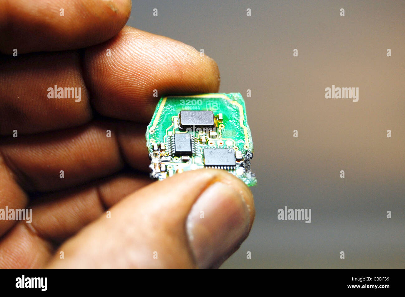 Car FOB or Remote Circuit Board Held Between Fingers, Badly Damaged or ...