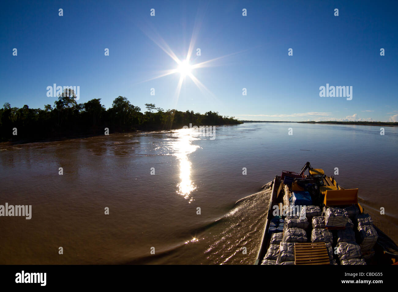 A large cargo ship moves slowly up the river Amazon to unload its cargo ...