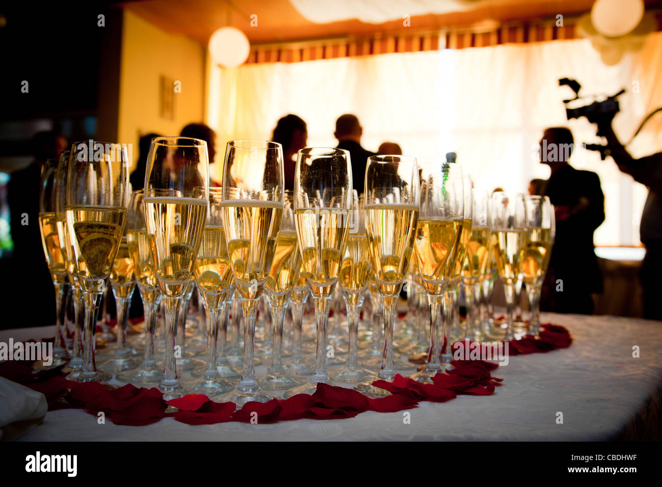 Champagne glasses at the party. People celebrate in the background ...