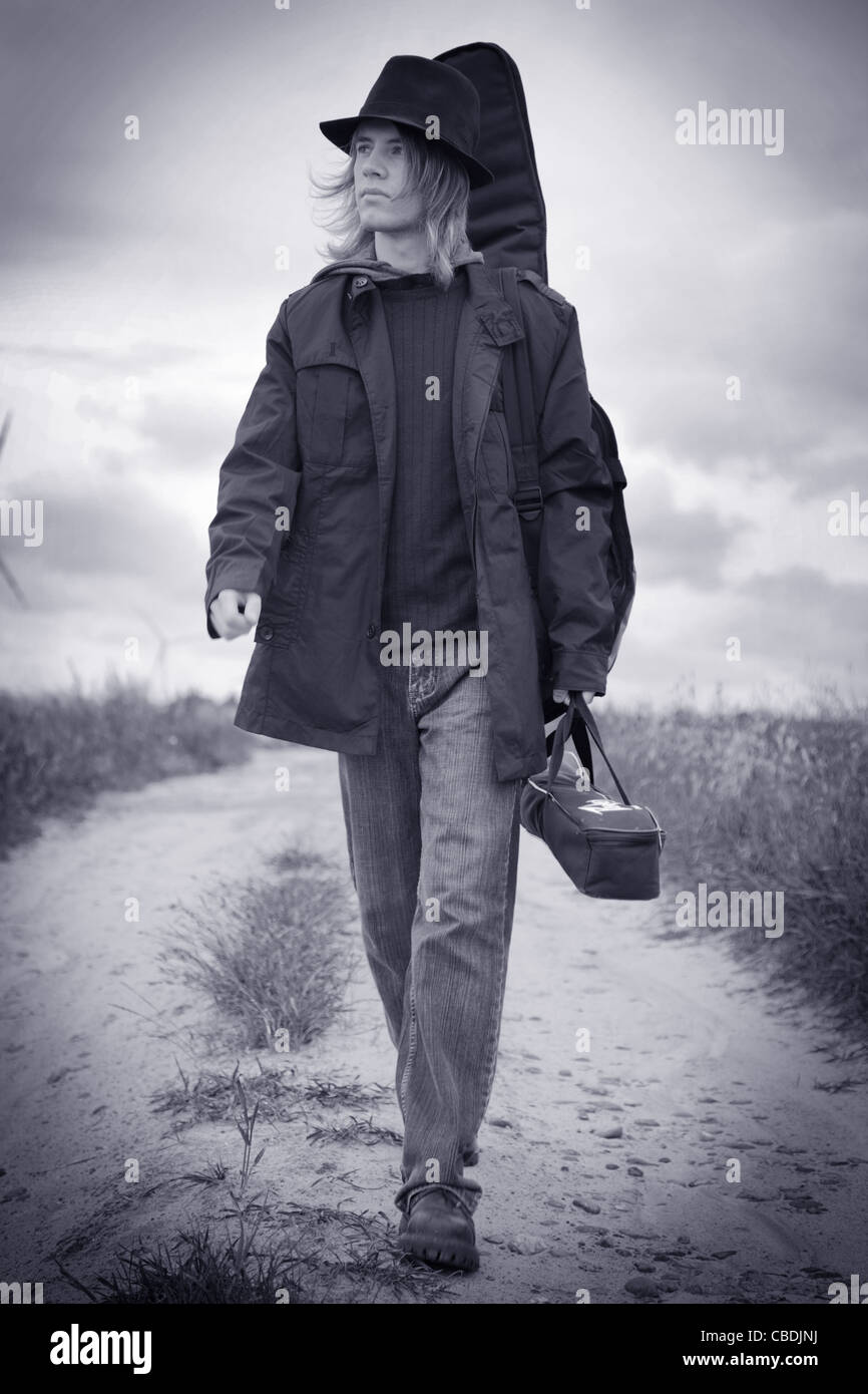 Full body portrait of a young musician walking on the field Stock Photo ...