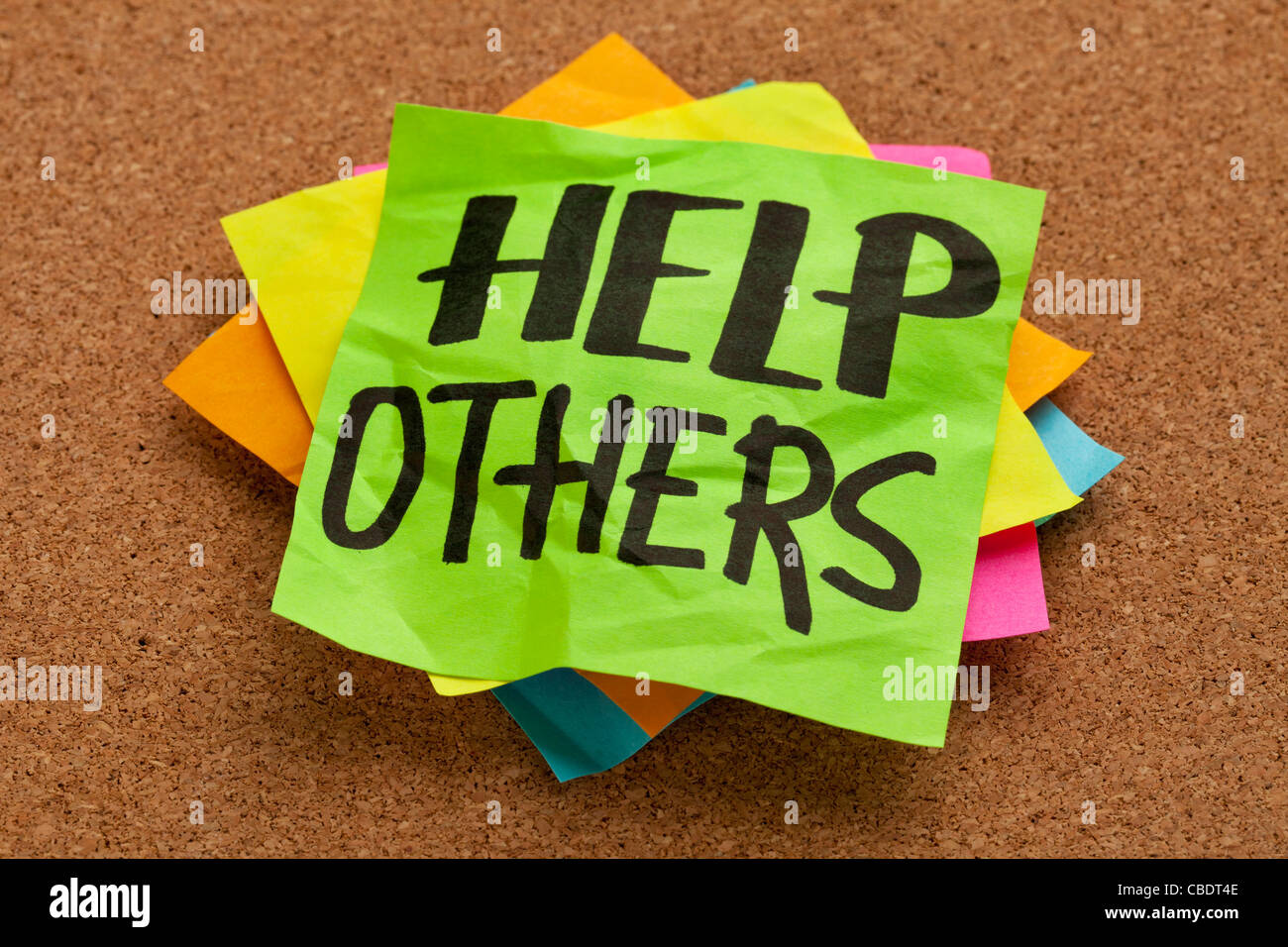 help others reminder on sticky note posted on a cork board Stock Photo ...