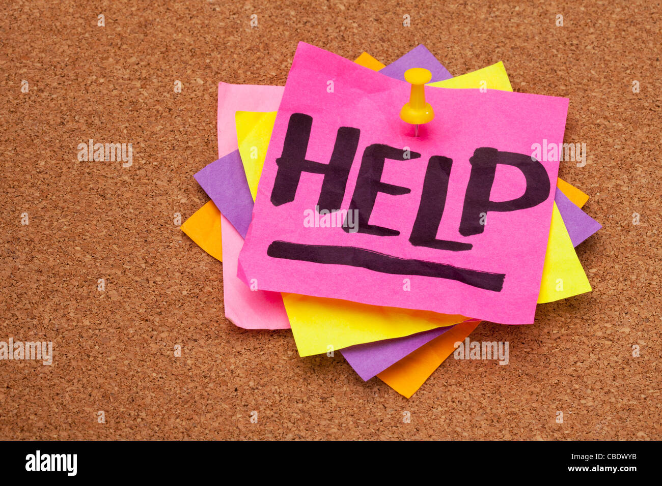 help - word handwritten on a stack of sticky notes posted on cork ...