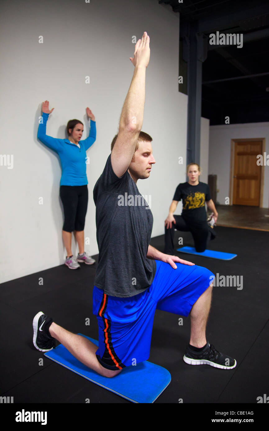 Group of athletes stretching after workout in gym Stock Photo - Alamy