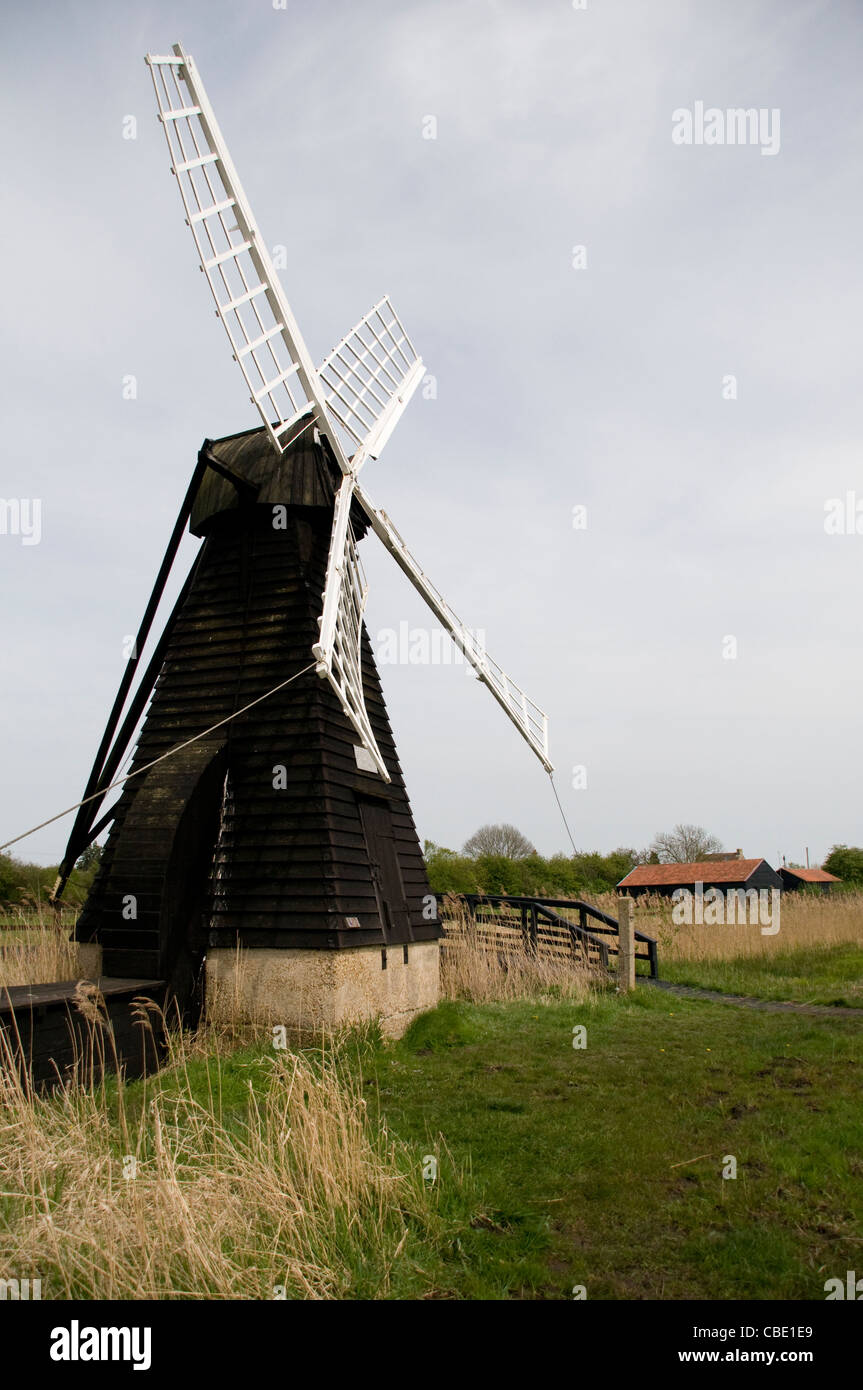 Windmill in Wicken Fen, white sails and black wood structure, buildings ...