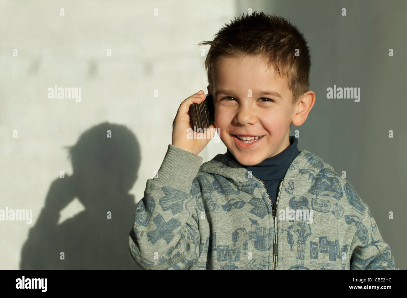 Smiling child talking by mobile phone Stock Photo - Alamy