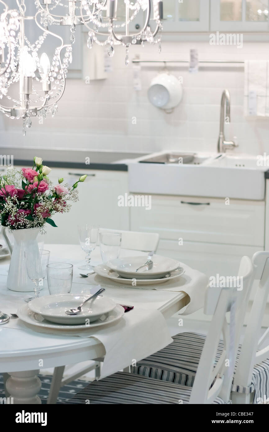 White decorated dining table with flowers in kitchen Stock Photo - Alamy