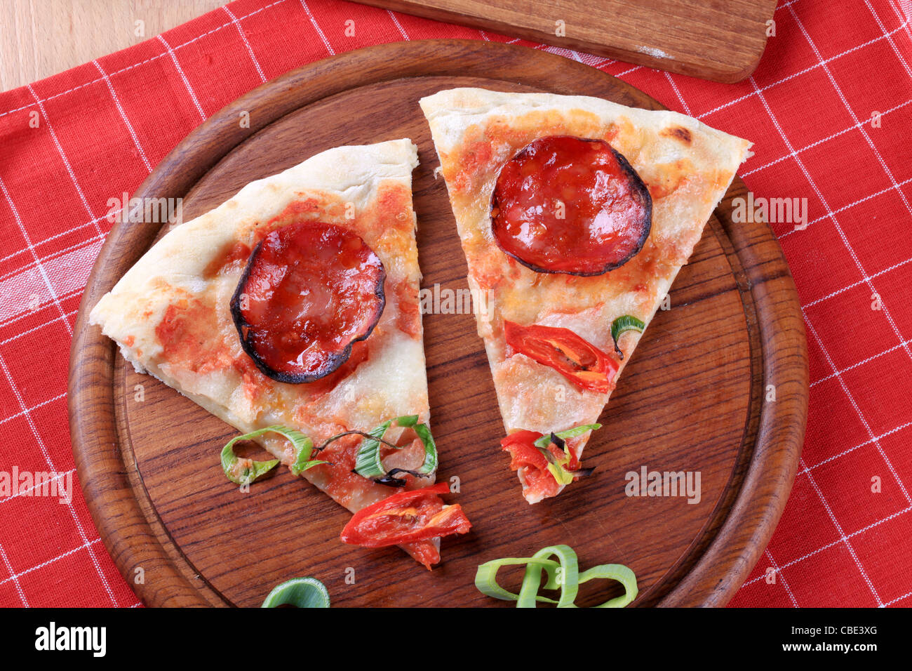 Two slices of pepperoni pizza on a cutting board Stock Photo - Alamy