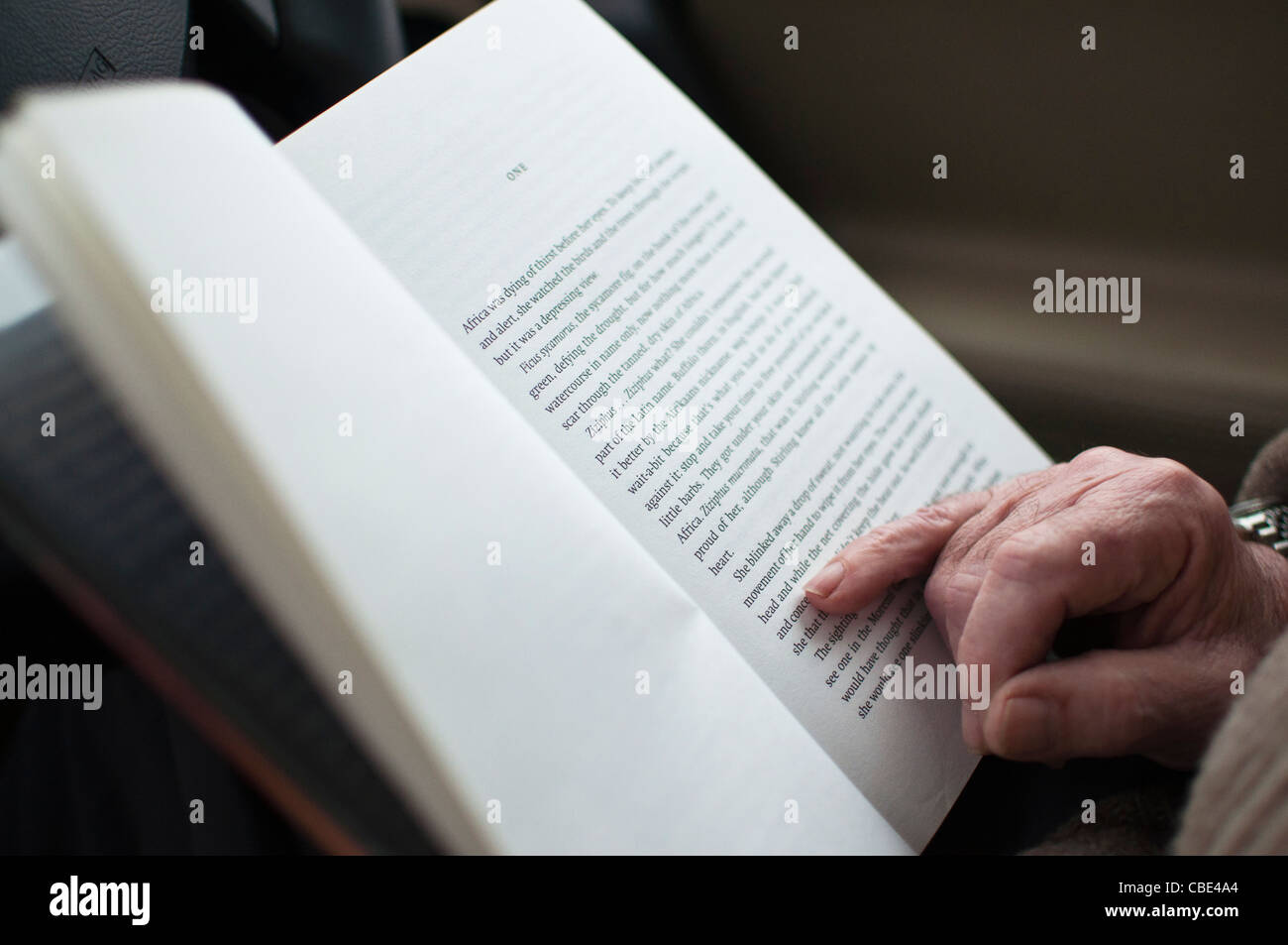 Close Up of a Hand of a Male Tracing Text with Finger, Whilst Reading A ...