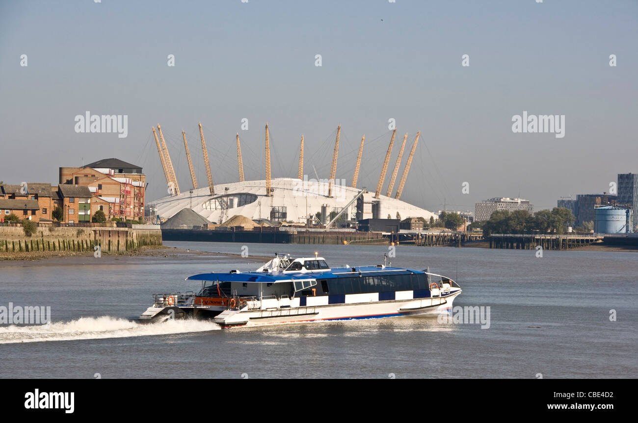 River bus speeding along Thames with 02 Arena and Isle of Dogs in ...