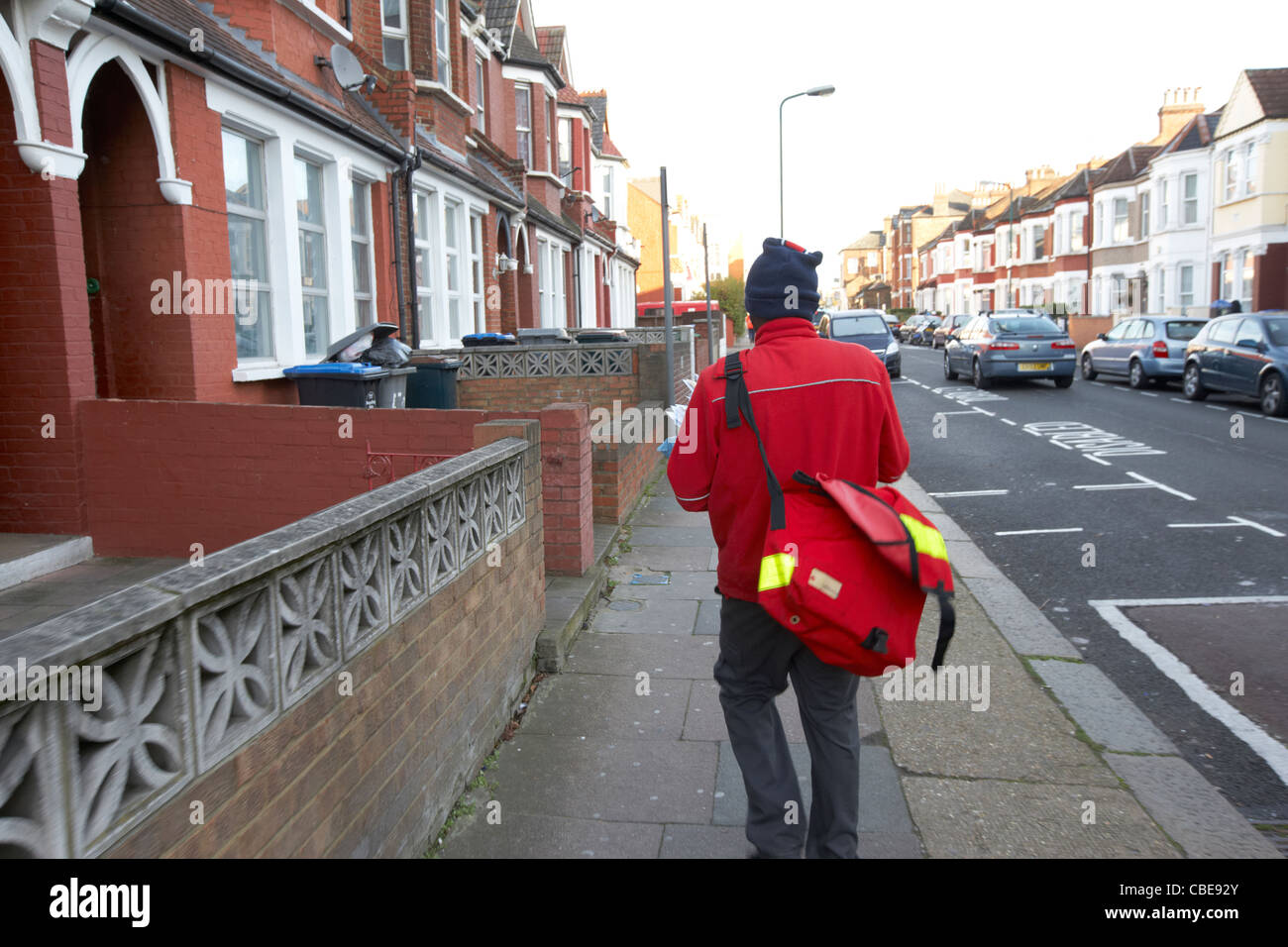 postman delivering mail on a cold december morning in cricklewood north ...
