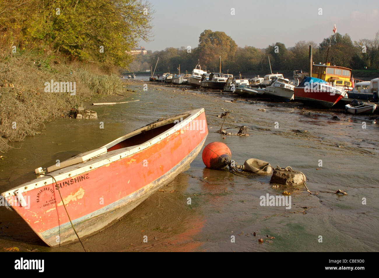 a small boat sits in very low tide along the River Thames in Richmond ...