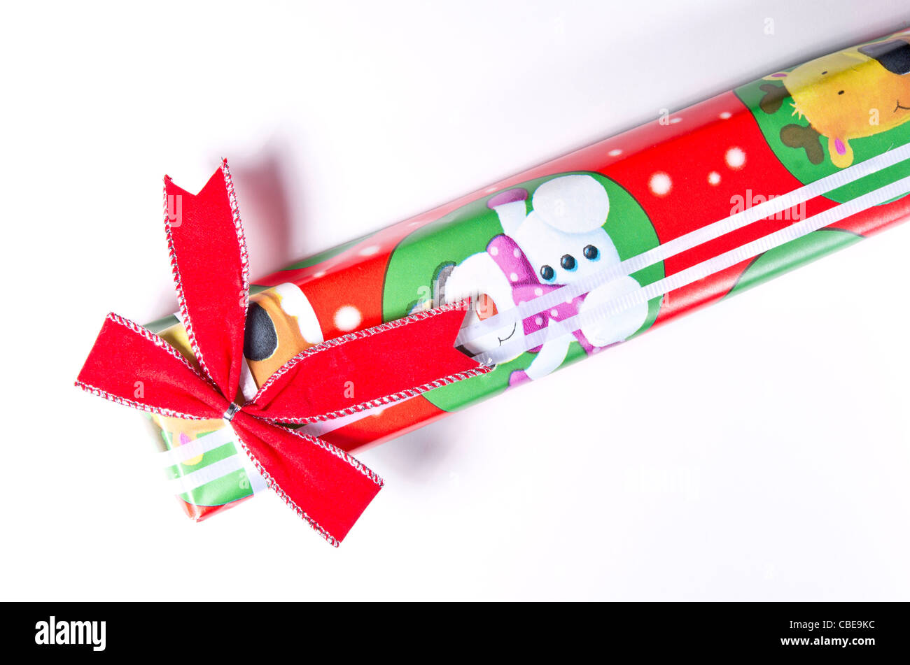 A long rectangular wrapped Christmas present with a red velvet bow and ...