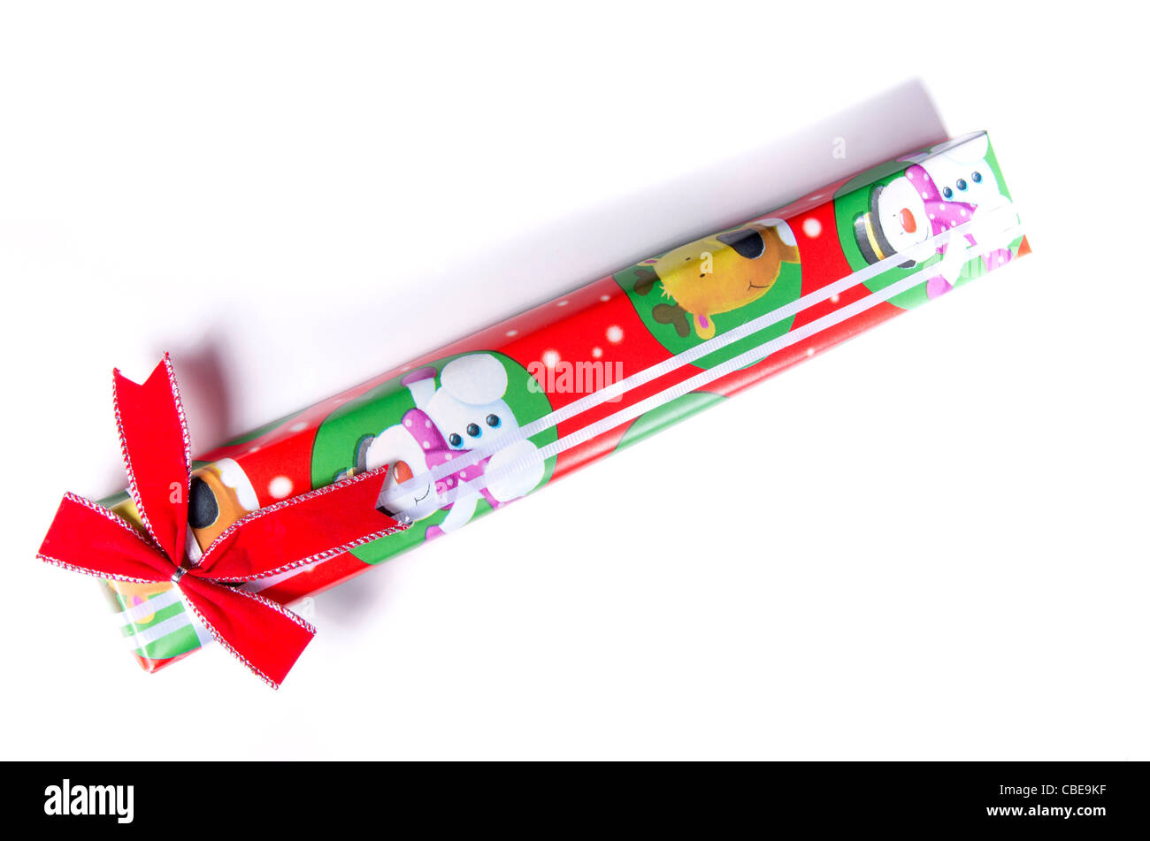 A long rectangular wrapped Christmas present with a red velvet bow and ...