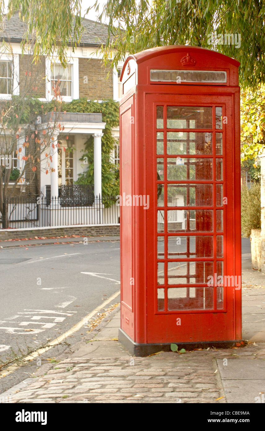 A traditional British red telephone box on a scenic residential street ...