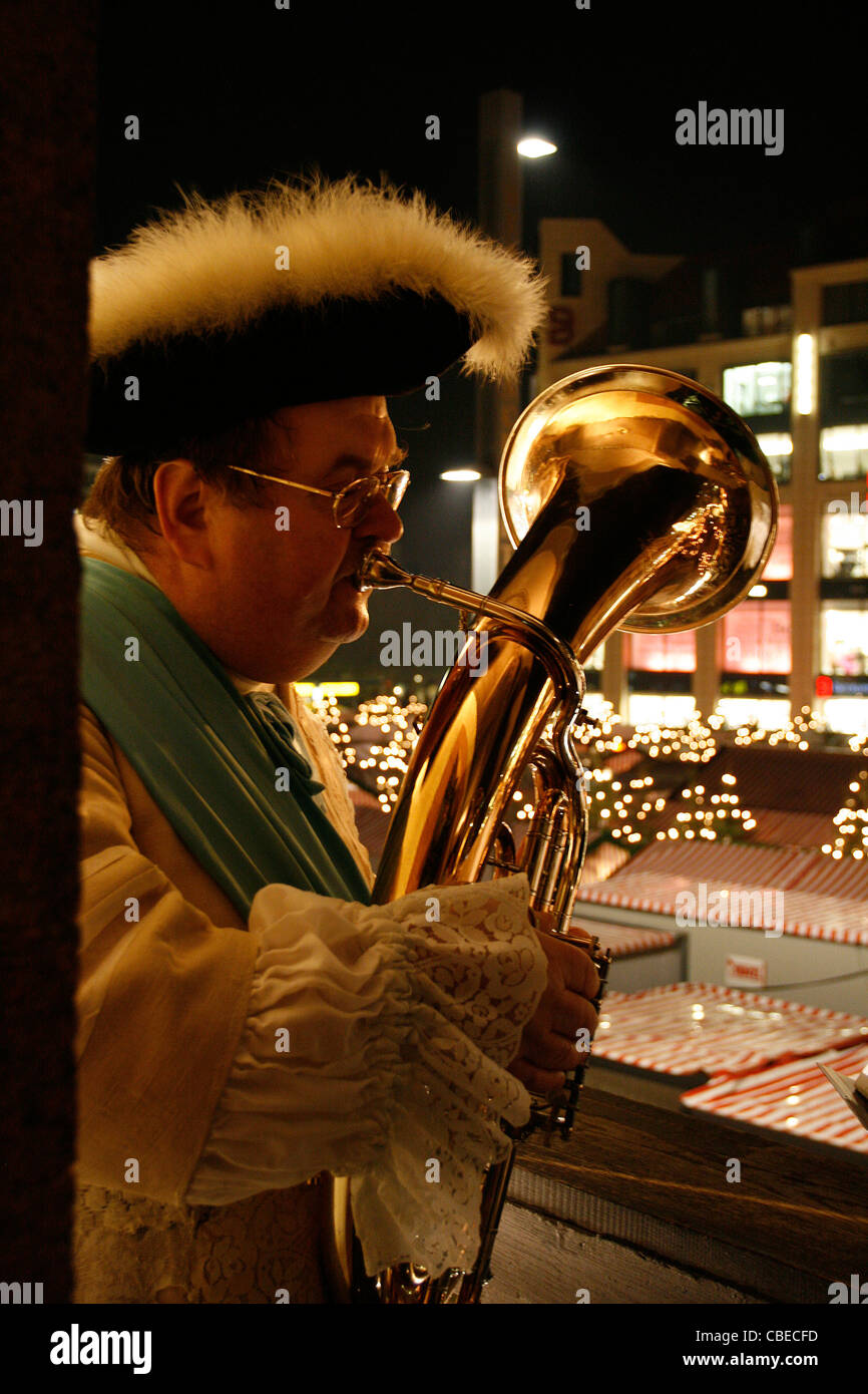 A local horn player with view on the Christmas market playing Christmas ...