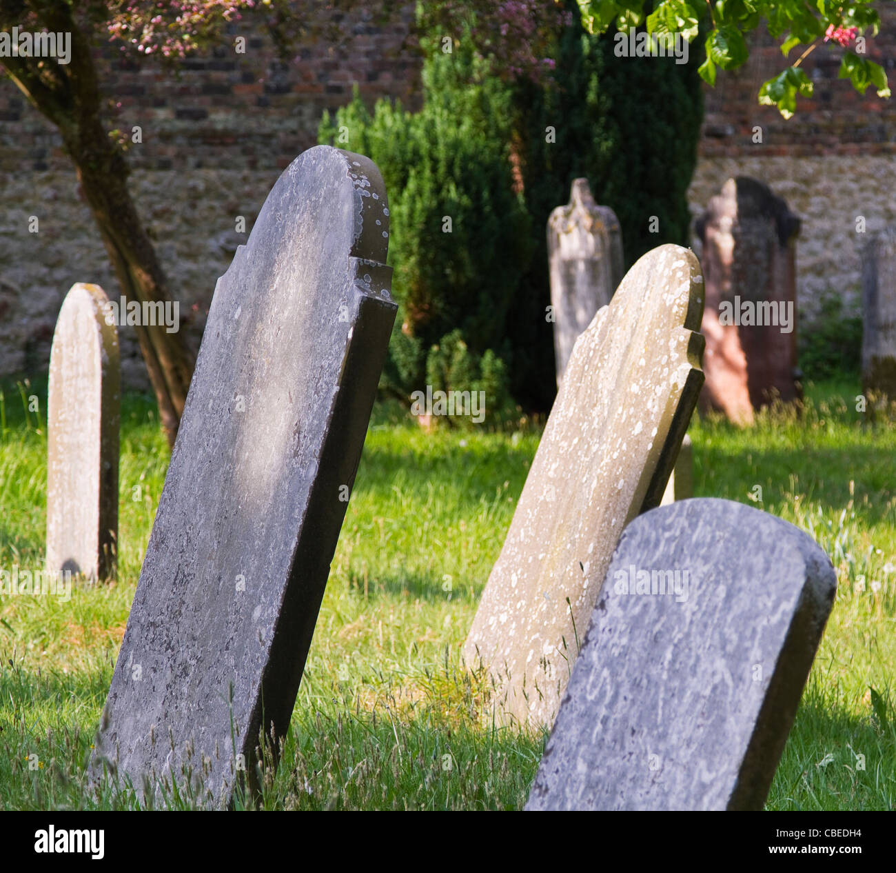 Old gravestones in a sunny country cemetery leaning over Stock Photo ...