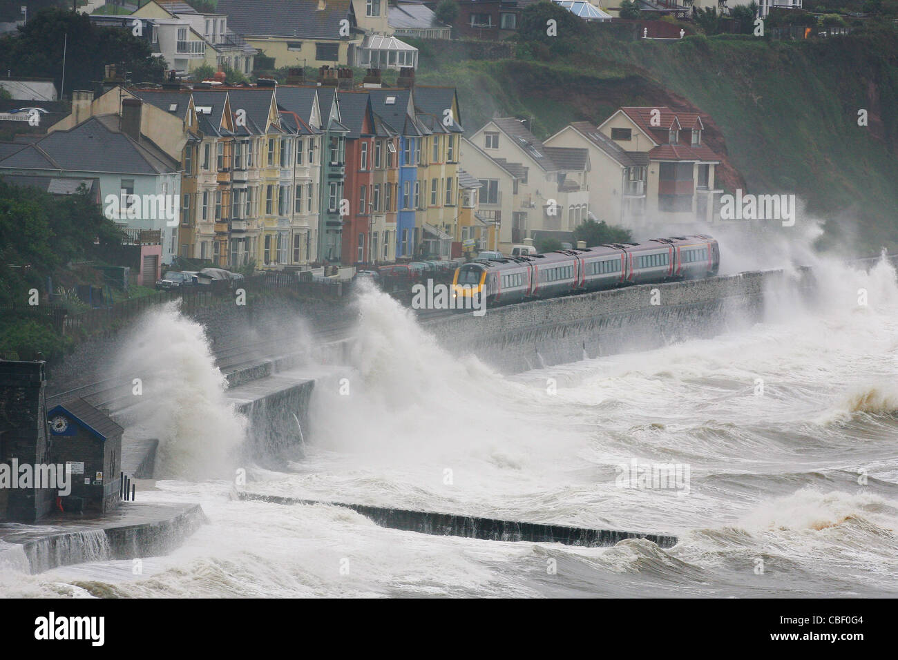 Waves crash onto a train as it heads into Dawlish station during ...