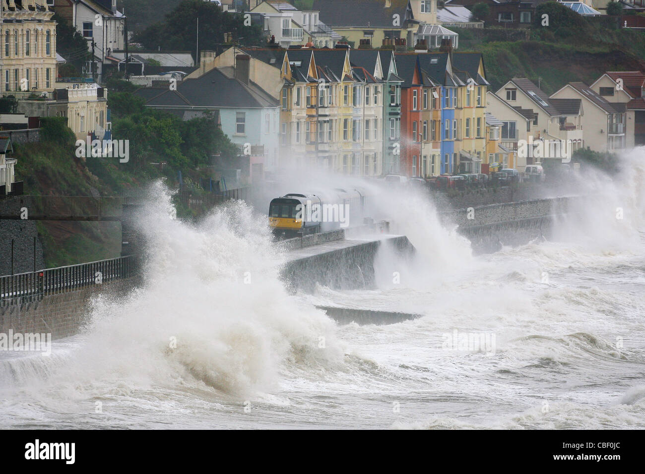 Waves crash onto a train as it heads into Dawlish station during ...