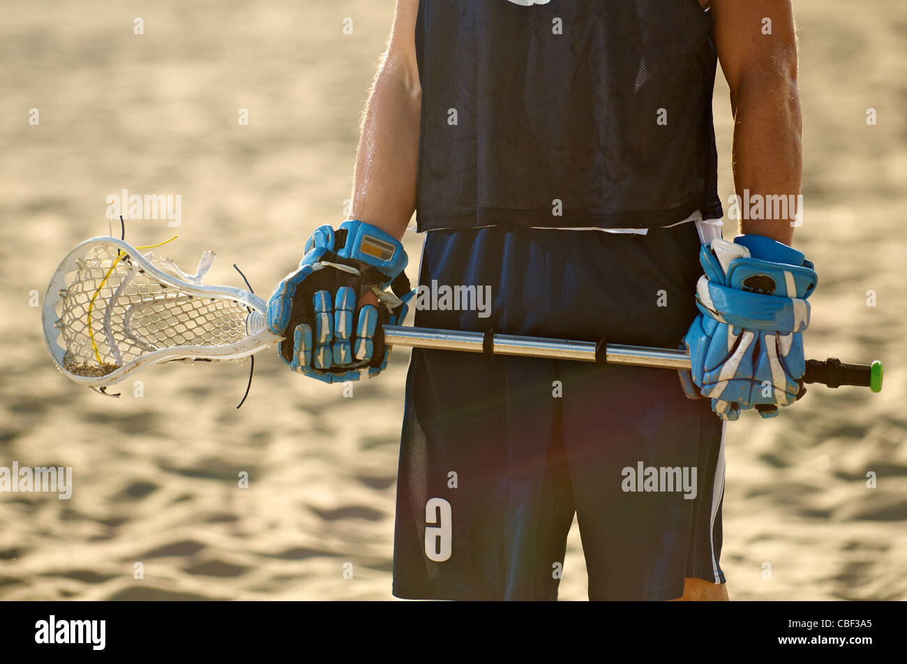 Detail of a lacrosse athlete with his stick on the beach Stock Photo ...