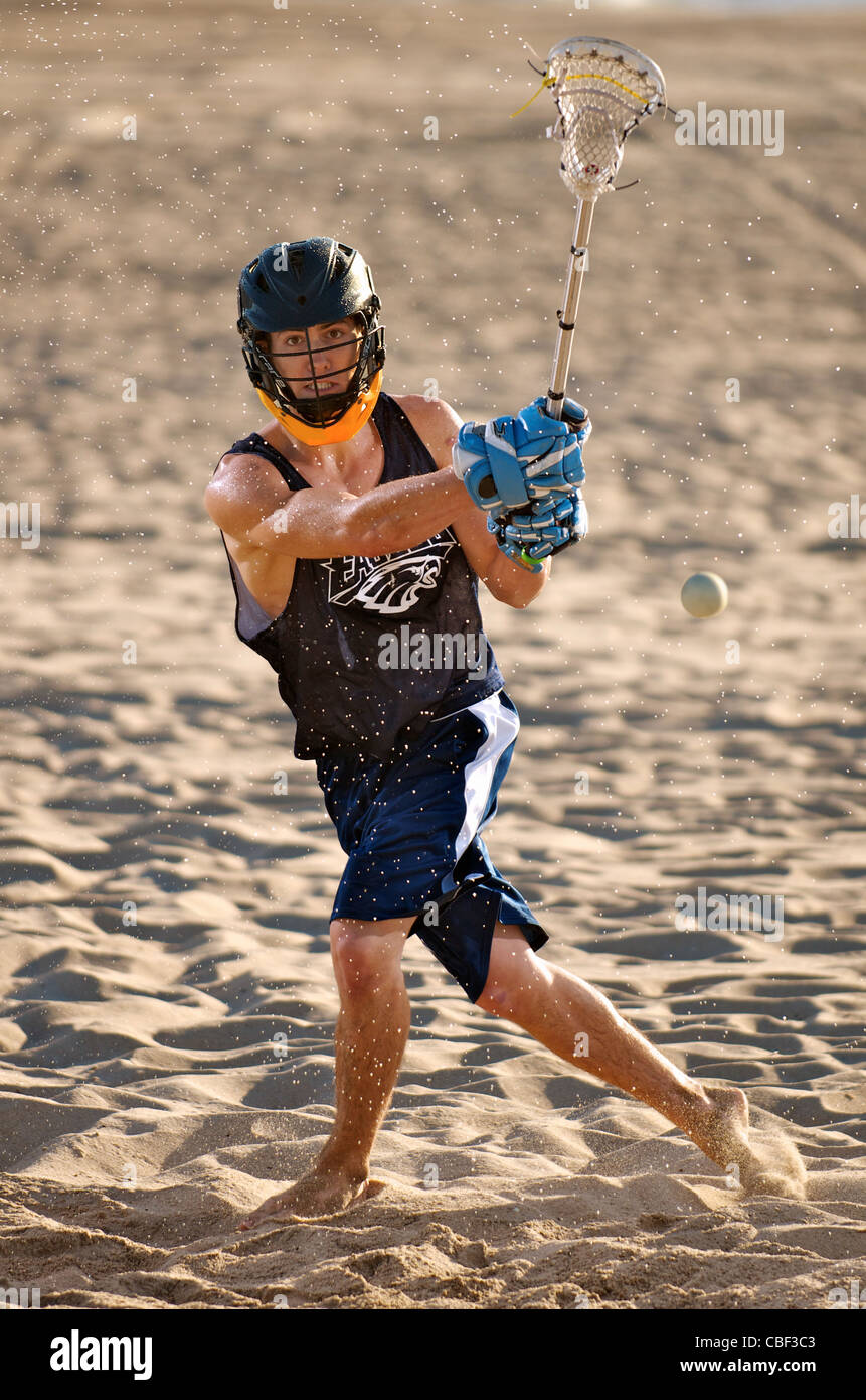 A male lacrosse athlete playing on the beach Stock Photo - Alamy