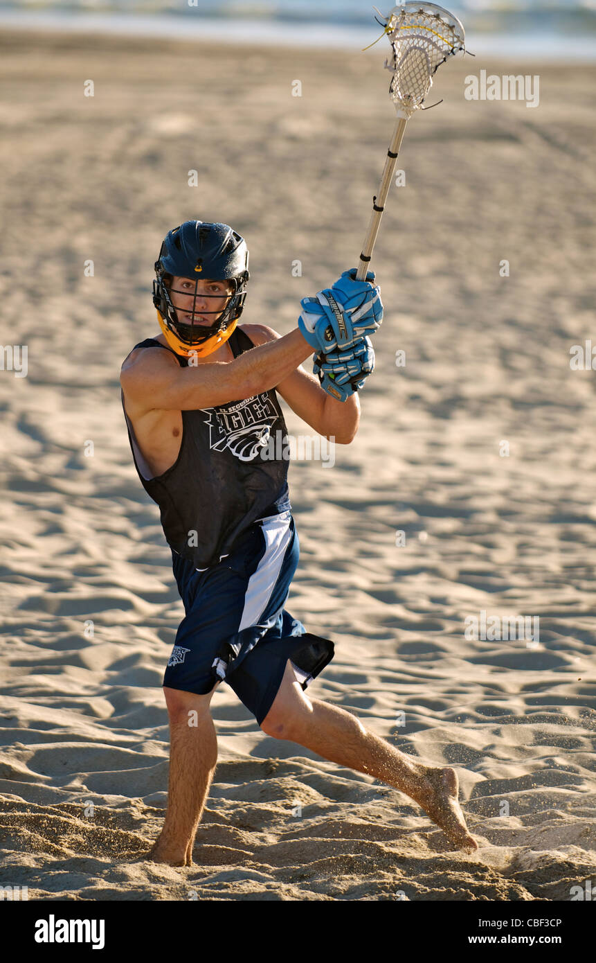 A male lacrosse athlete playing on the beach Stock Photo - Alamy