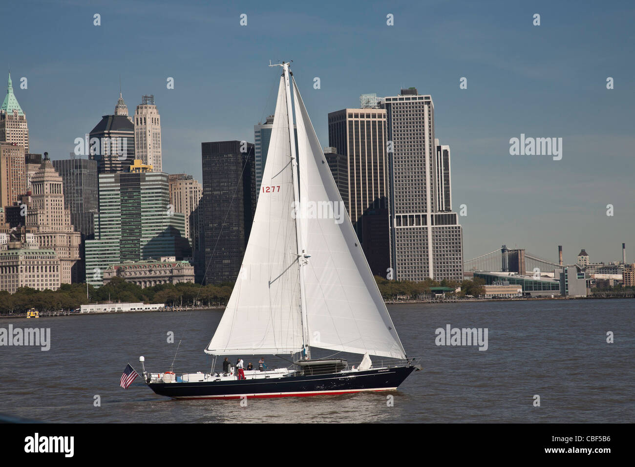 Sailboat under sail in New York Harbor, Lower Manhattan in Background ...