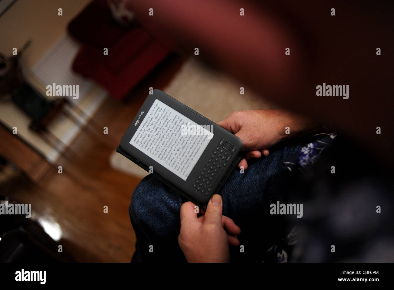Male reading a book using an Amazon Kindle device Photograph taken ...