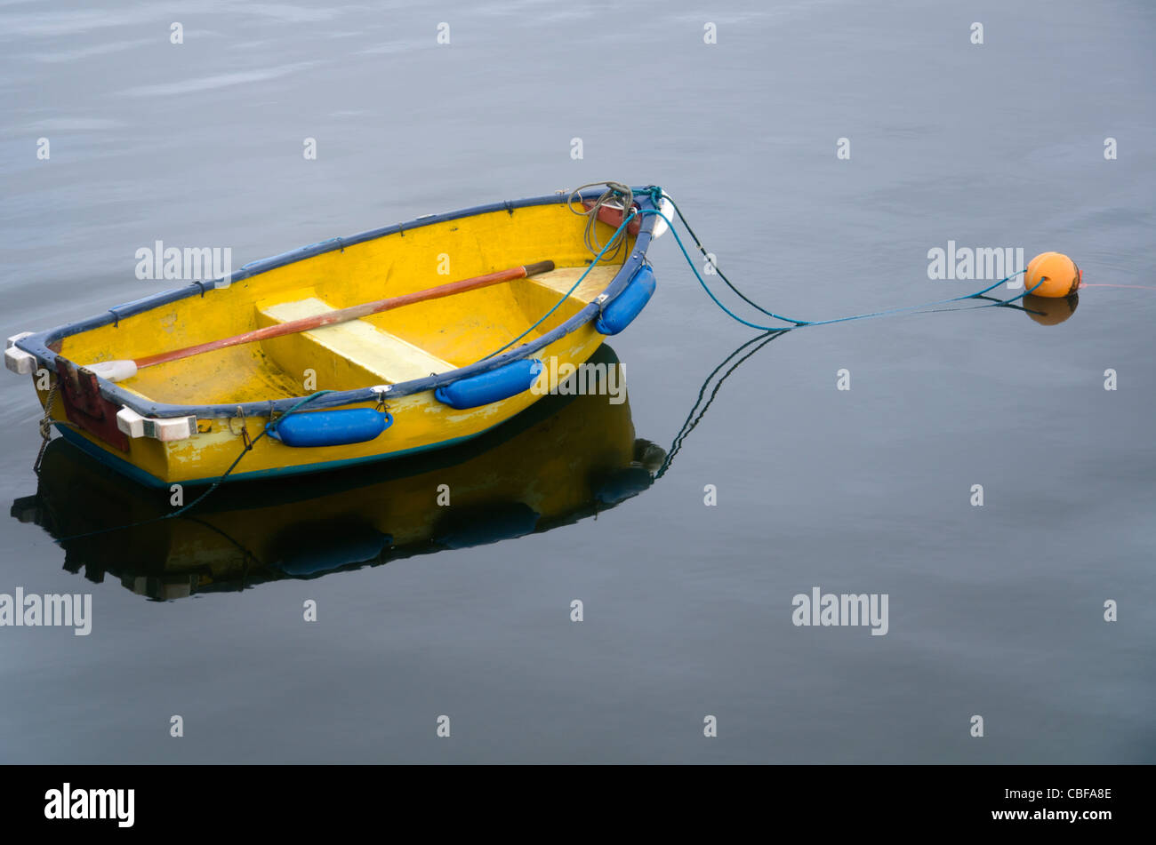 A lovely yellow dinghy moored in the harbour of Whitehaven Stock Photo ...
