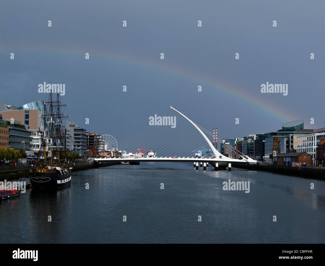Dublin arp shaped bridge with rainbow, an old ship docked and a ...