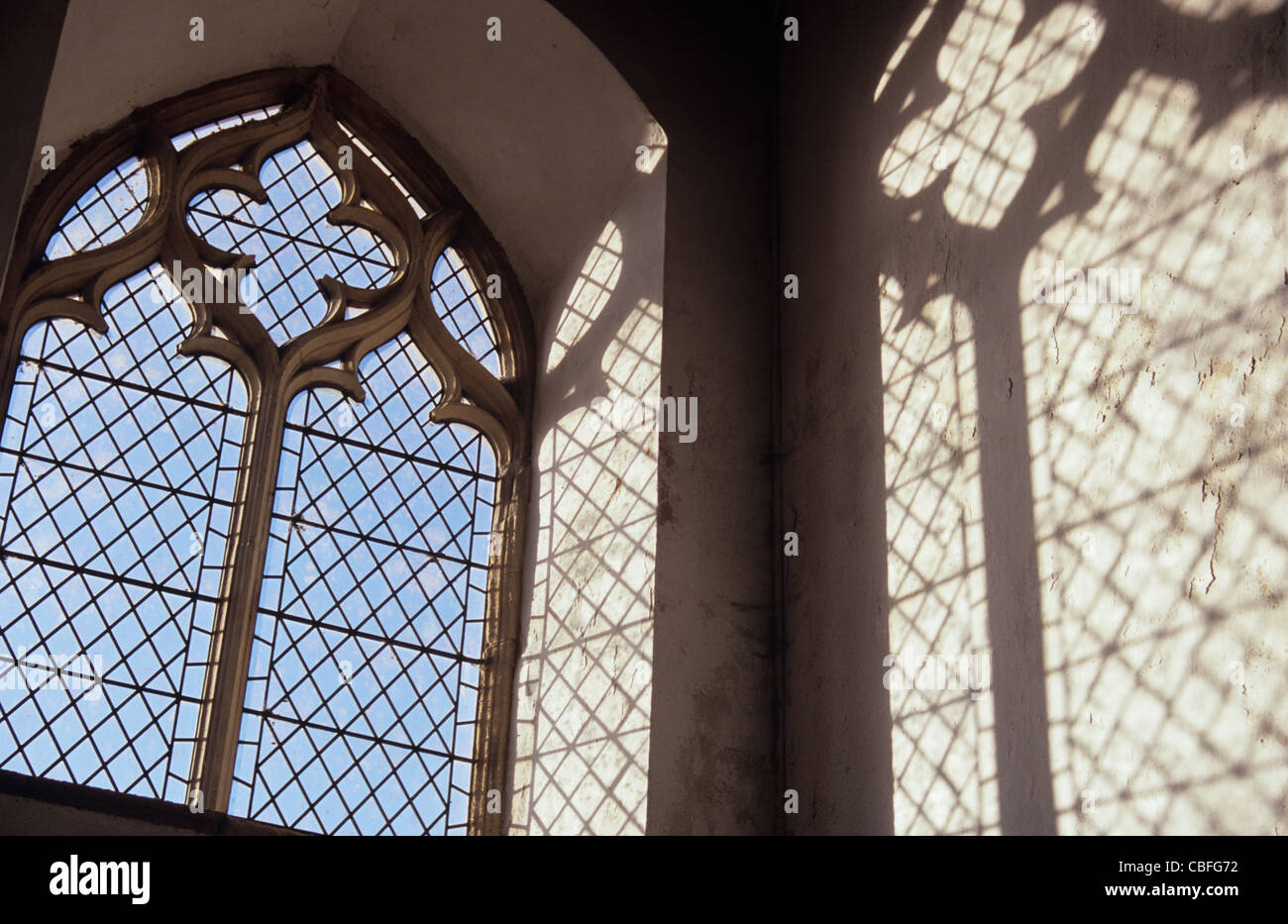 Sunlit diamond leaded Early English Gothic church window projecting its ...