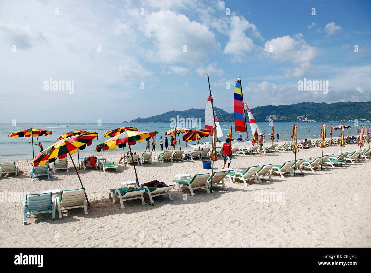 Holiday beach scene with sun loungers and umbrellas on sandy Patong ...
