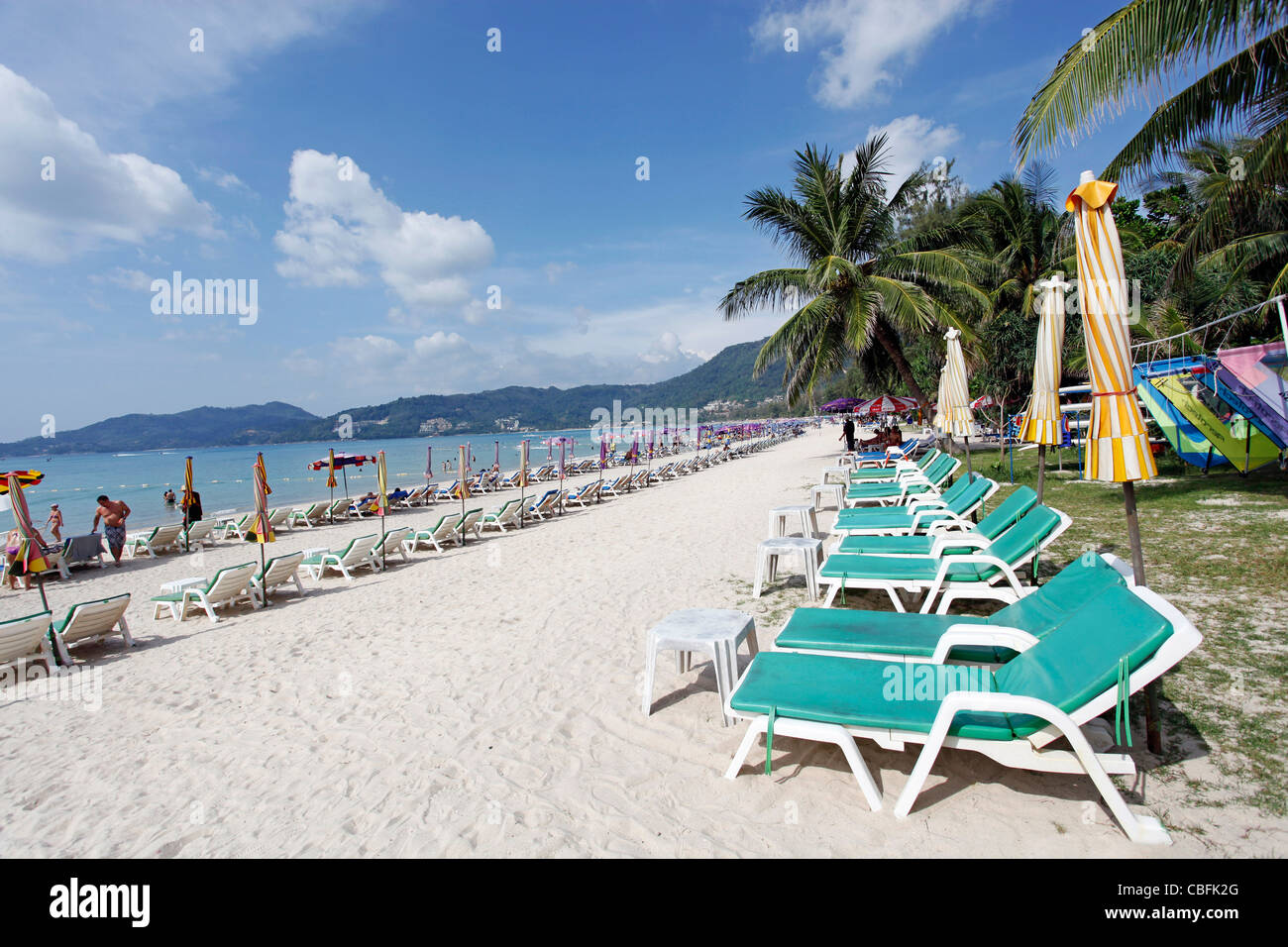 Holiday beach scene with sun loungers and umbrellas on sandy Patong ...