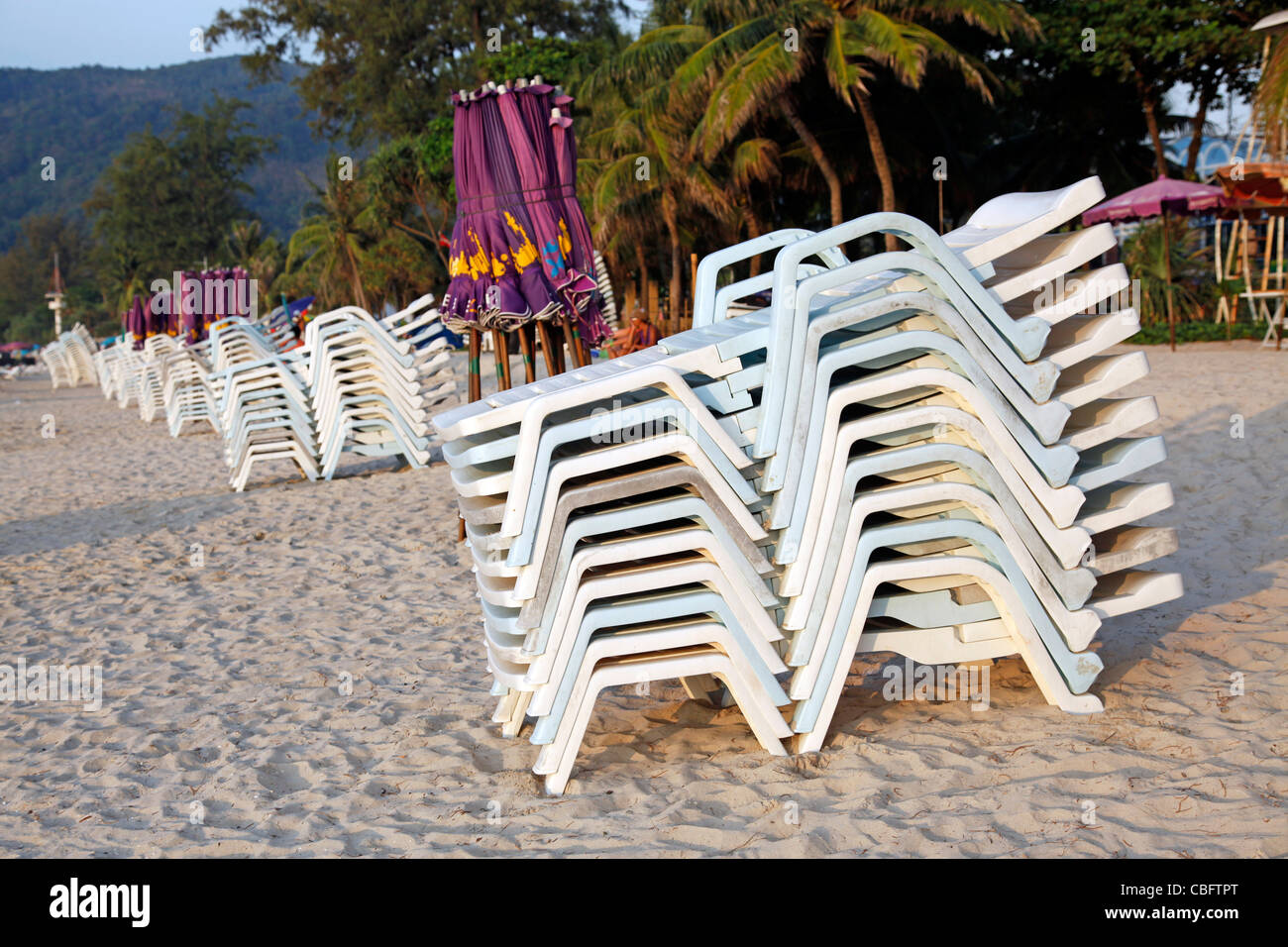 Holiday beach scene with sun loungers and umbrellas on sandy Patong ...