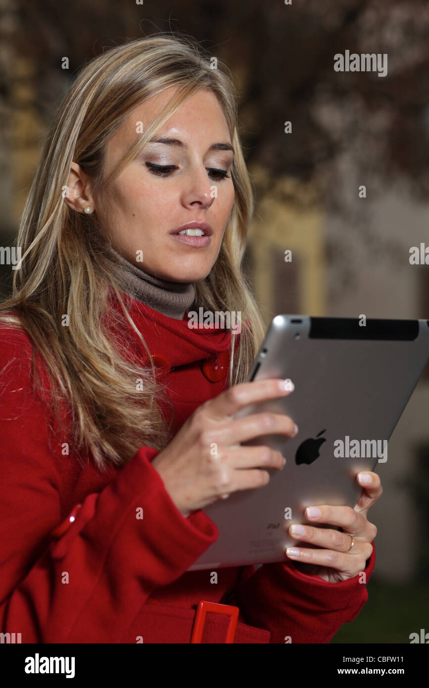 A young woman reading a newspaper on her iPad Stock Photo - Alamy