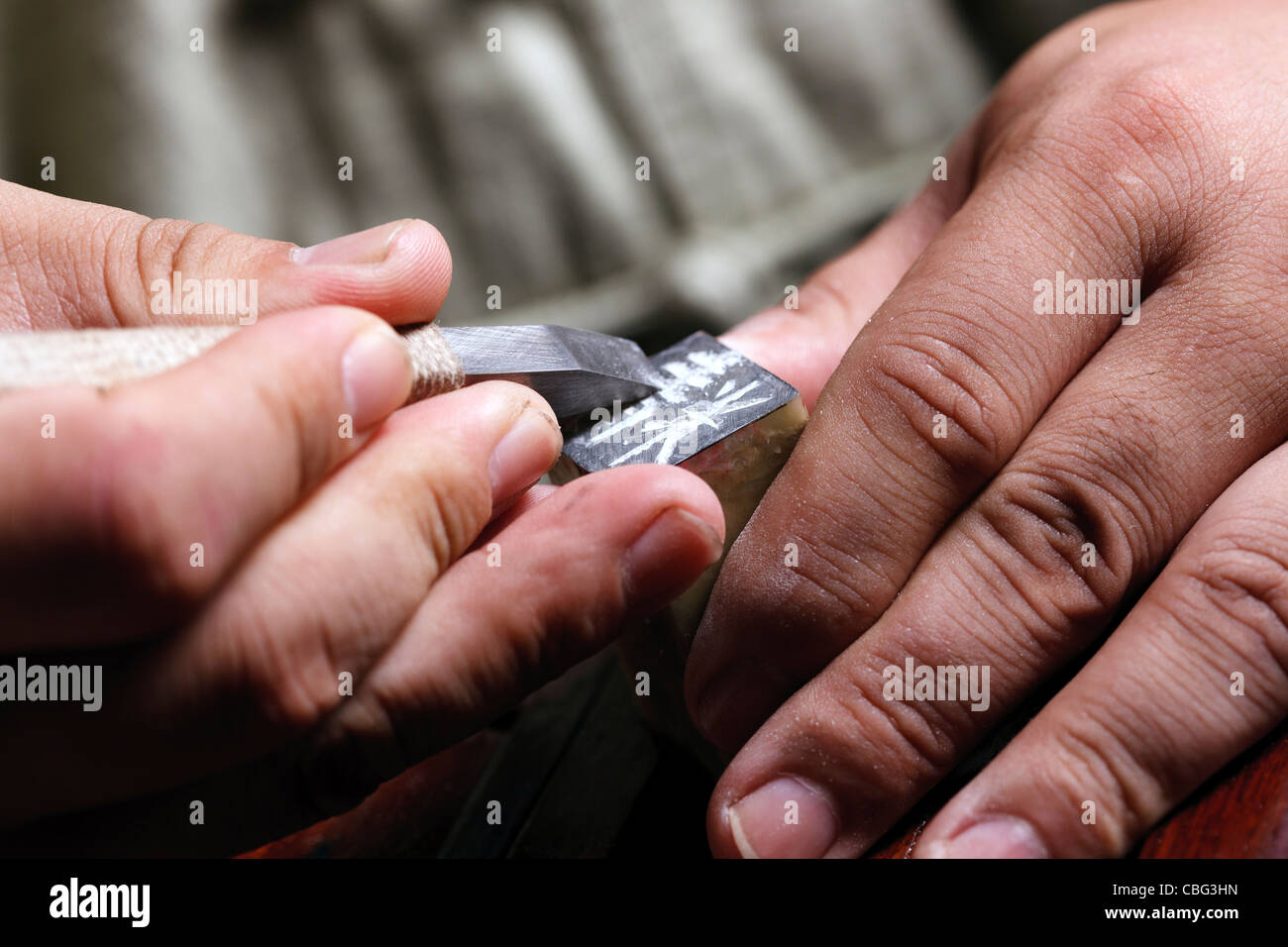 Craftsman carving Chinese character into a Chinese chop Stock Photo - Alamy