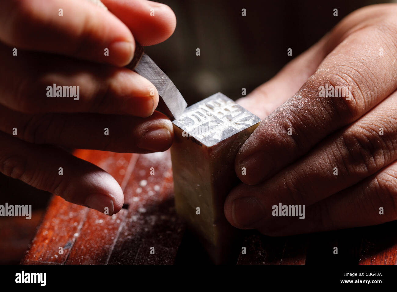 Craftsman carving Chinese character into a Chinese chop Stock Photo - Alamy