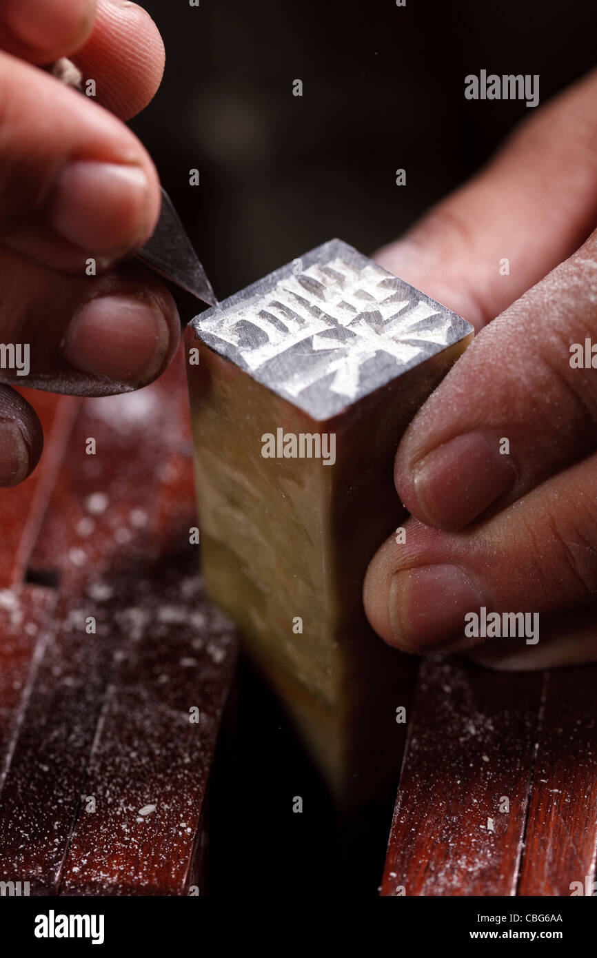 Craftsman carving Chinese character into a Chinese chop Stock Photo - Alamy