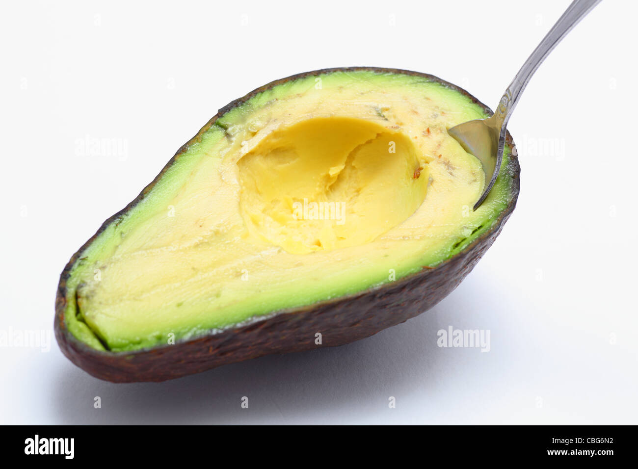 Sliced avocado, complete with spoon ready to eat Stock Photo - Alamy