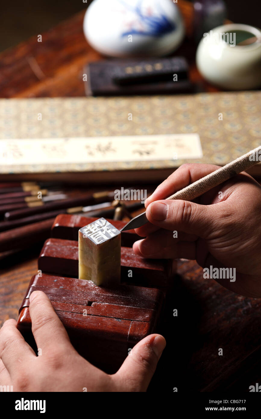 Craftsman carving Chinese character into a Chinese chop Stock Photo - Alamy