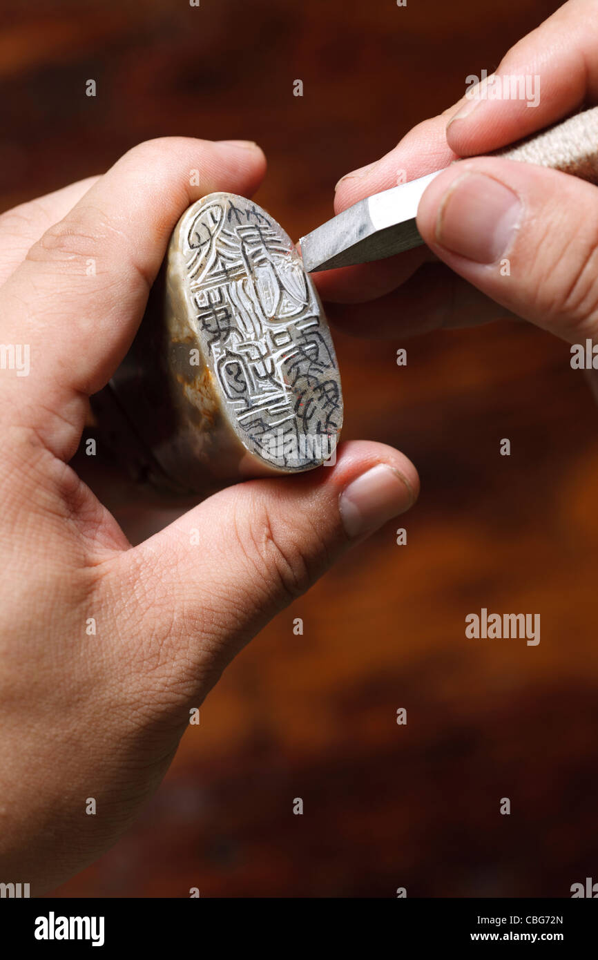 Craftsman carving Chinese character into a Chinese chop Stock Photo - Alamy