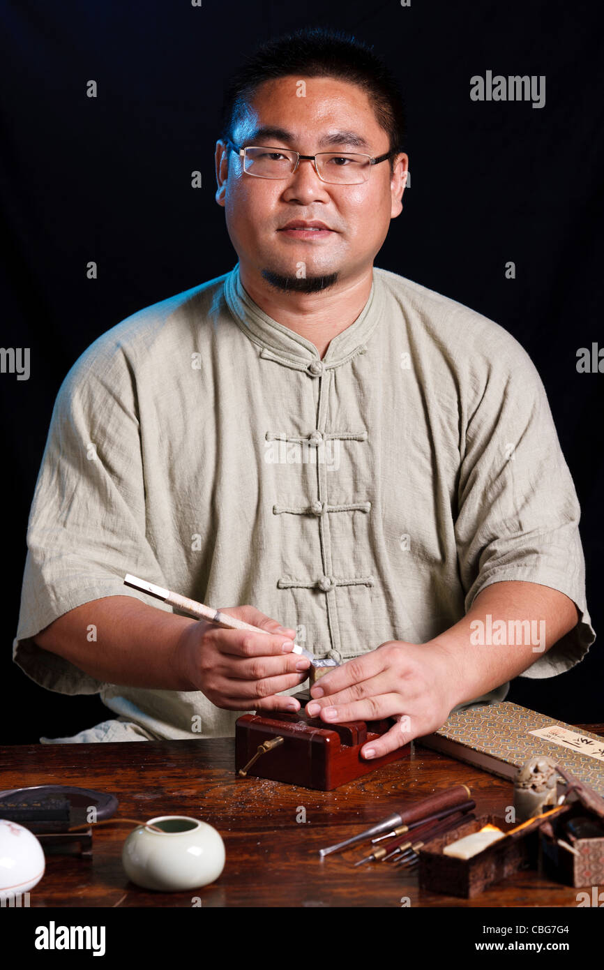 Craftsman carving Chinese character into a Chinese chop Stock Photo - Alamy