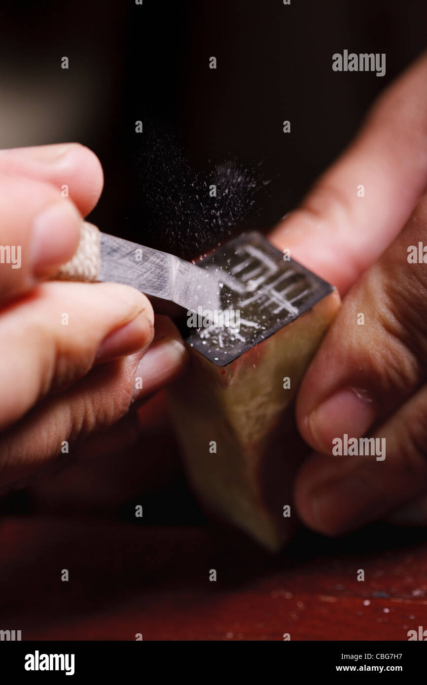 Craftsman carving Chinese character into a Chinese chop Stock Photo - Alamy