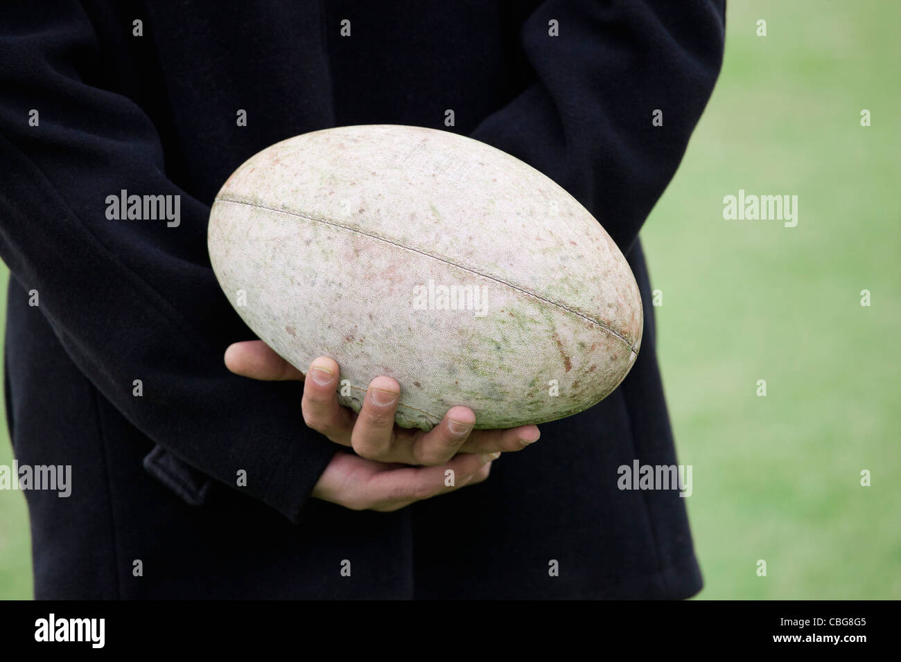 A man holding a rugby ball behind his back, close-up of hands Stock ...