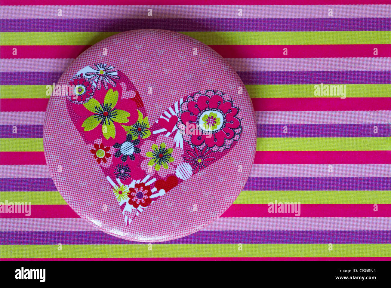 Colourful heart round pin badge on stripy background Stock Photo - Alamy