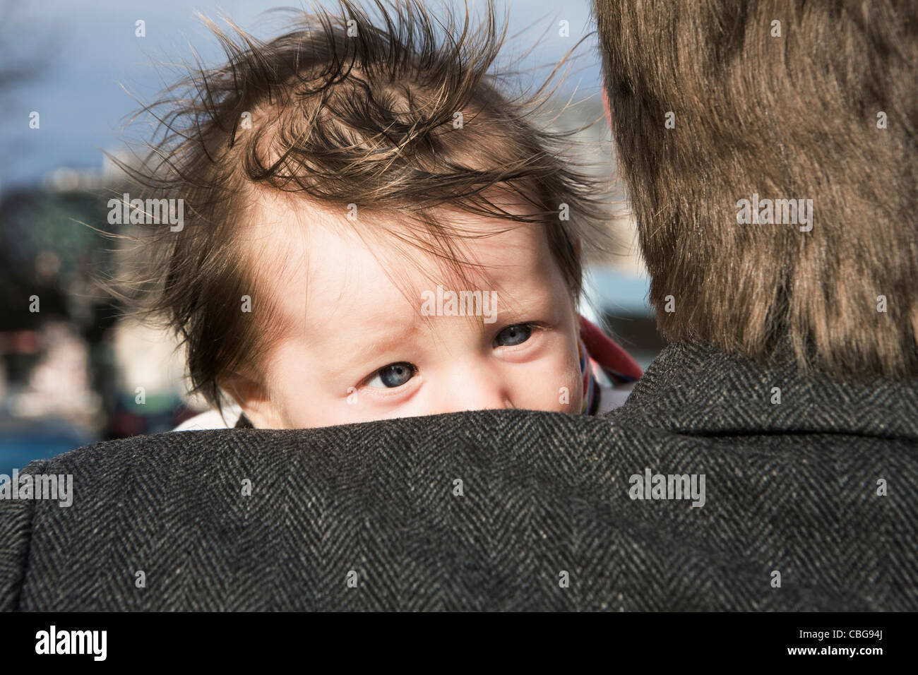 A newborn looking over her father's shoulder, over the shoulder view ...