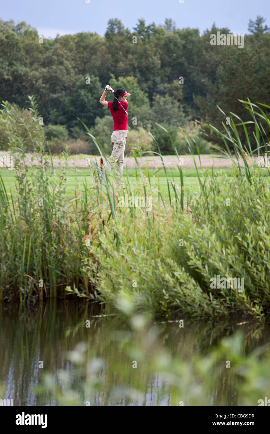A female golfer teeing off Stock Photo - Alamy
